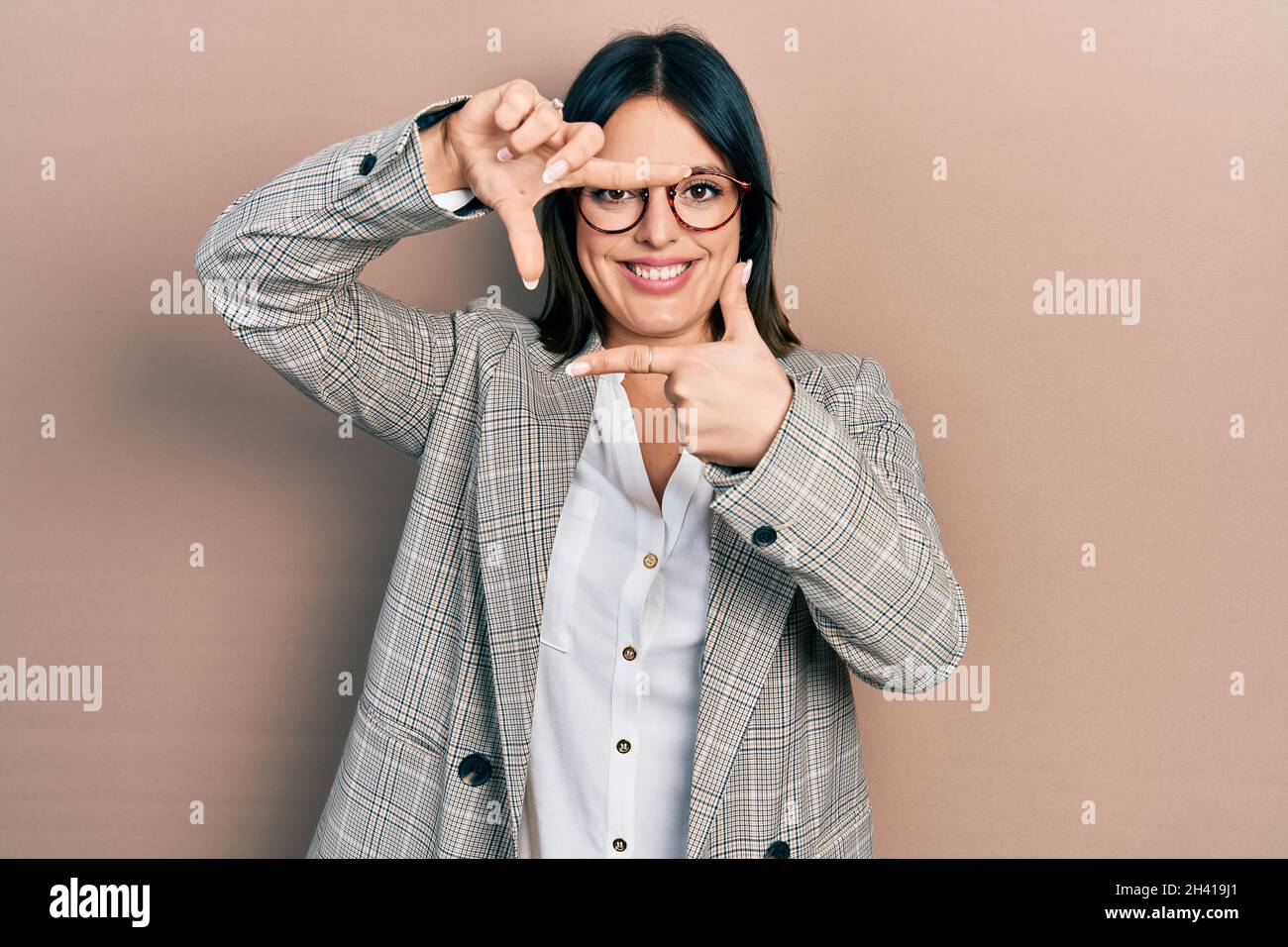 Young hispanic woman wearing business clothes and glasses smiling ...