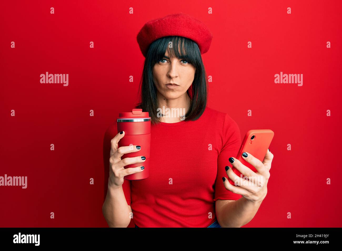 Young hispanic woman using smartphone and drinking a cup of coffee ...