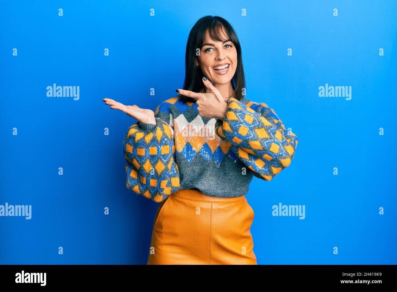 Young hispanic woman wearing casual winter sweater amazed and smiling ...