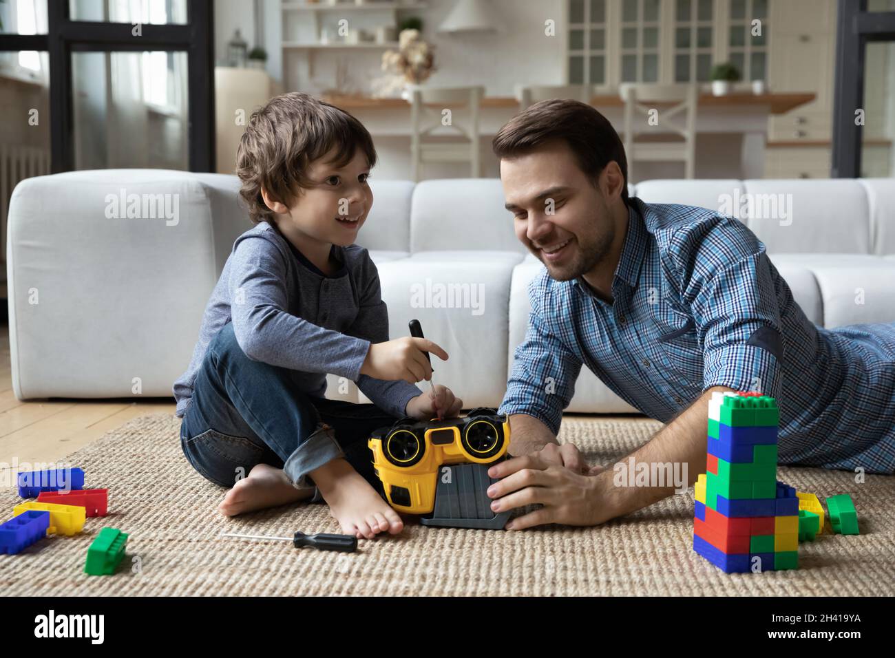 Happy adorable little child son fixing toy car with father Stock Photo ...