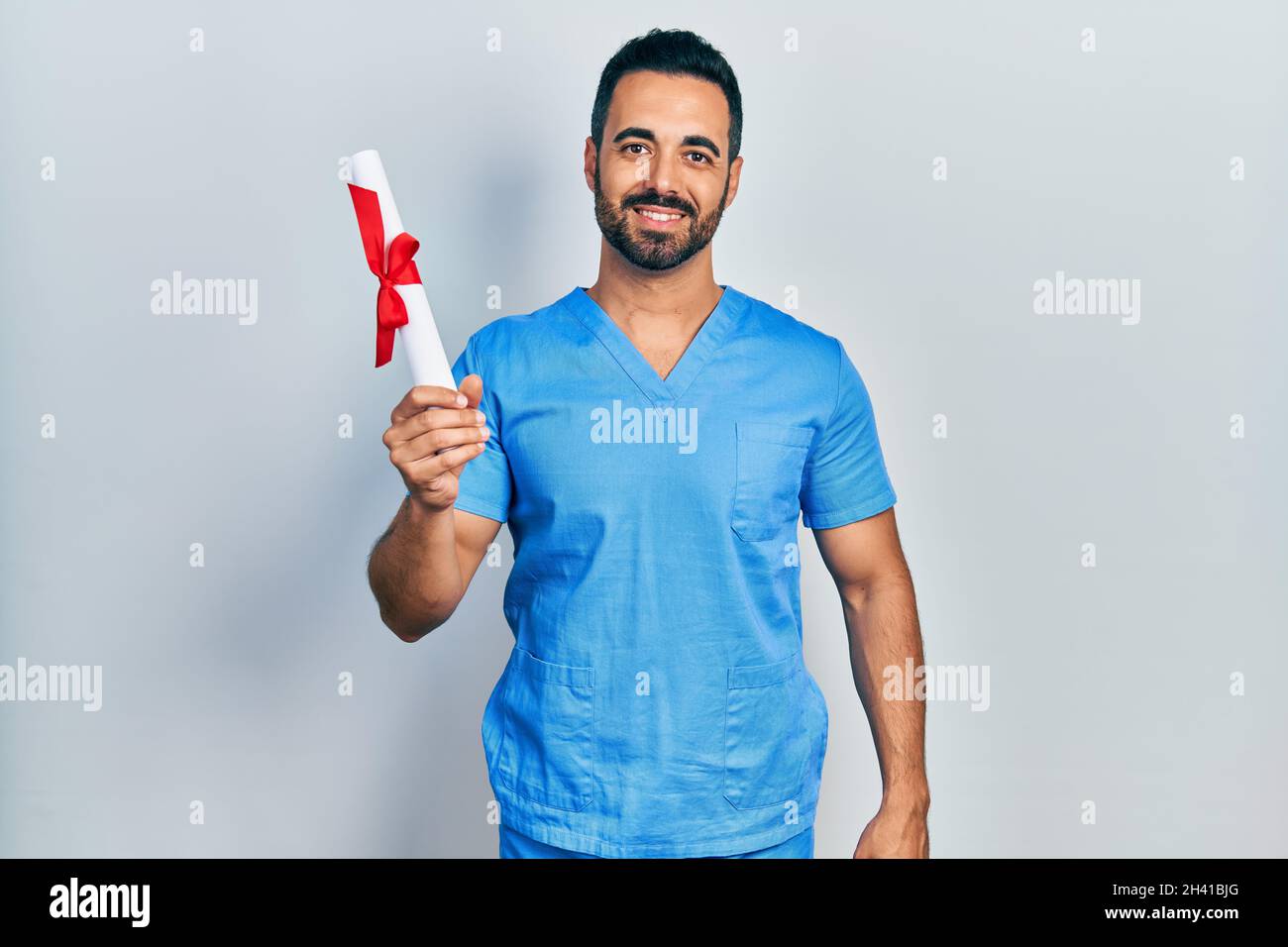 Handsome hispanic man with beard wearing blue male nurse uniform ...