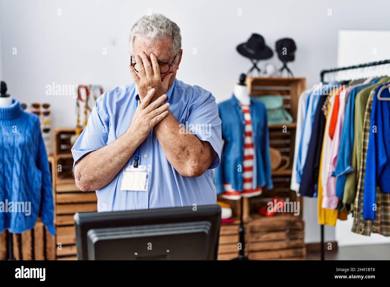 Senior man with grey hair working as manager at retail boutique with ...