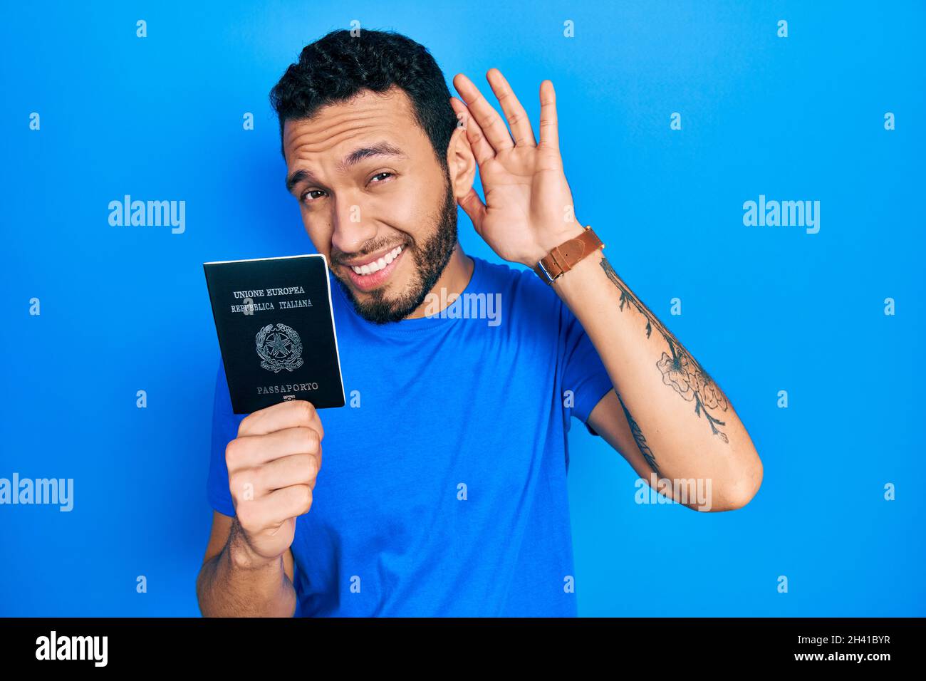 Hispanic man with beard holding italy passport smiling with hand over ...