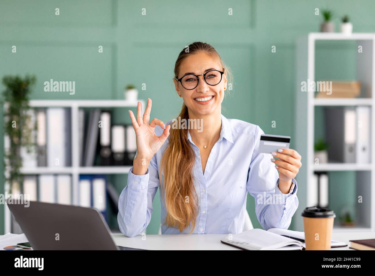 Accountant banker lady holding credit card and showing ok sign while ...