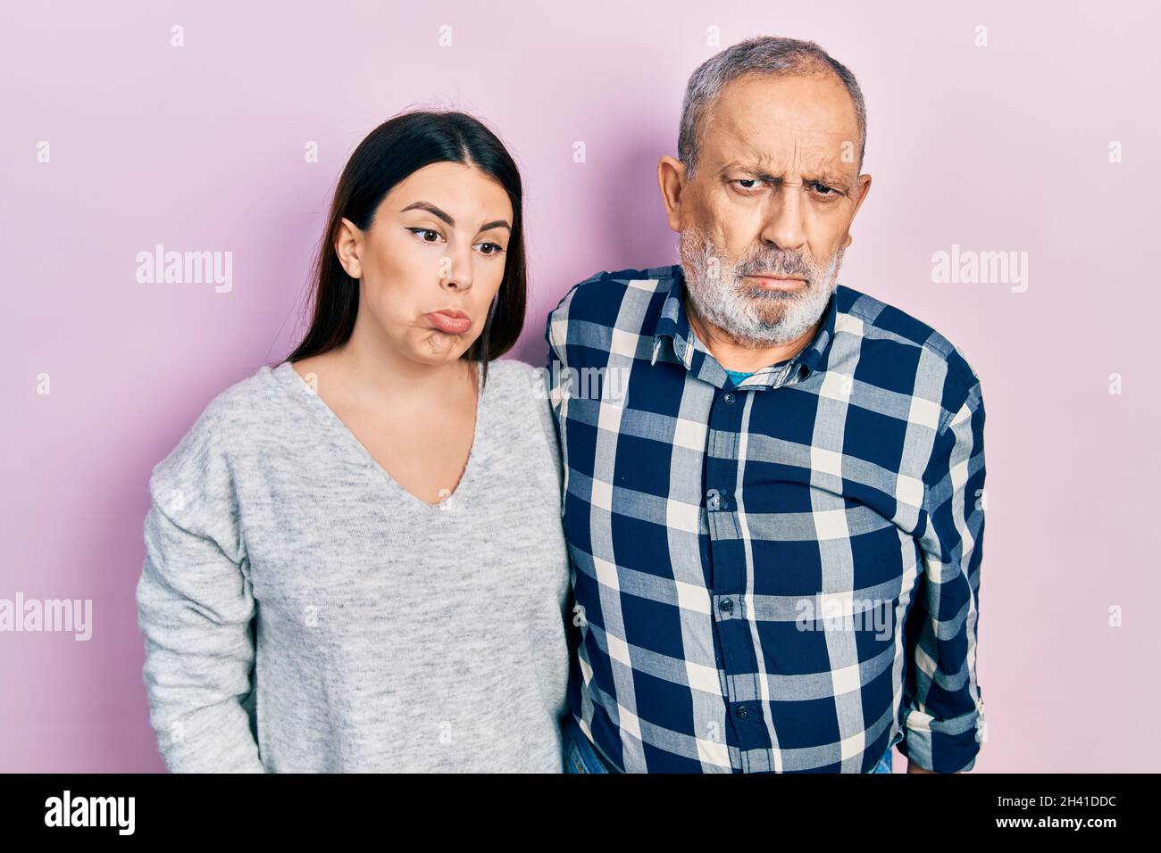 Hispanic father and daughter wearing casual clothes depressed and worry ...