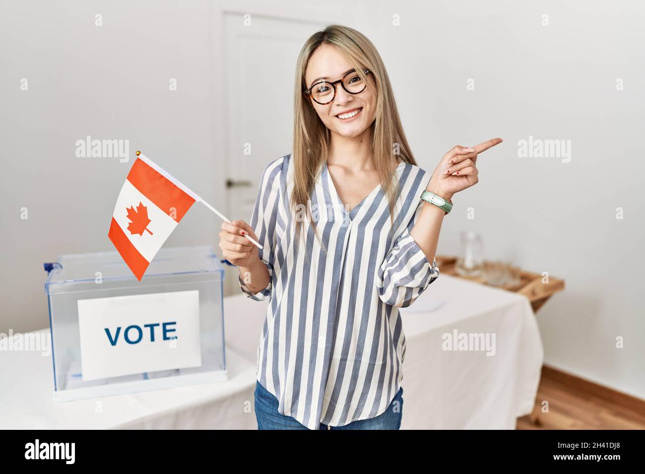 Asian young woman at political campaign election holding canada flag ...