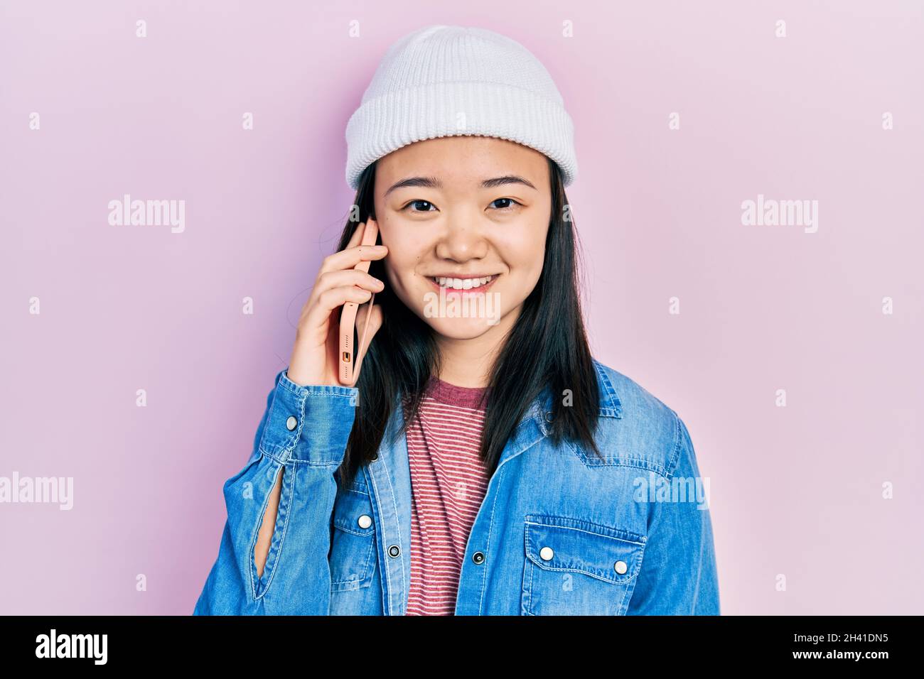Young chinese girl having conversation talking on the smartphone ...