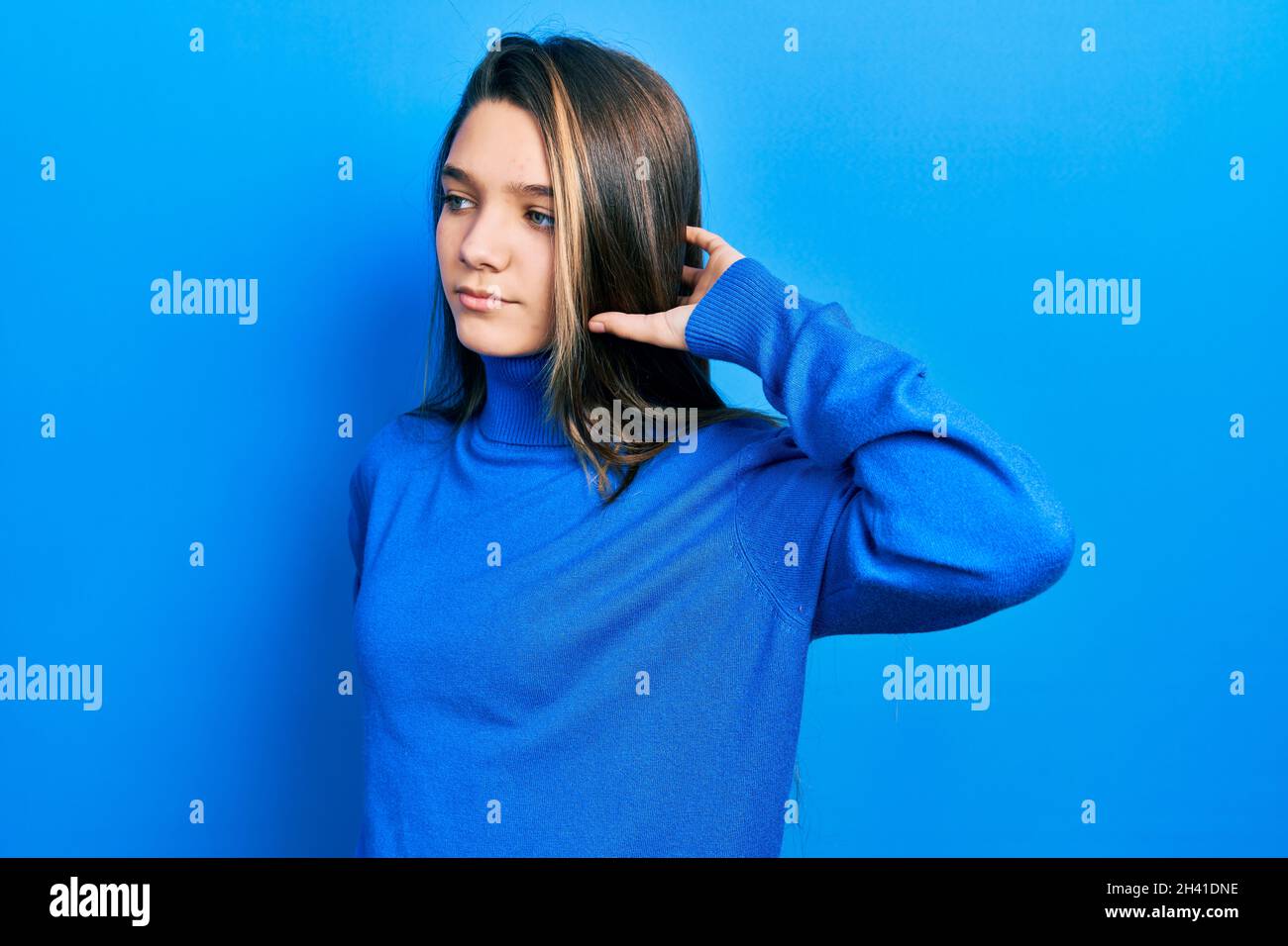 Young brunette girl wearing turtleneck sweater suffering of neck ache ...