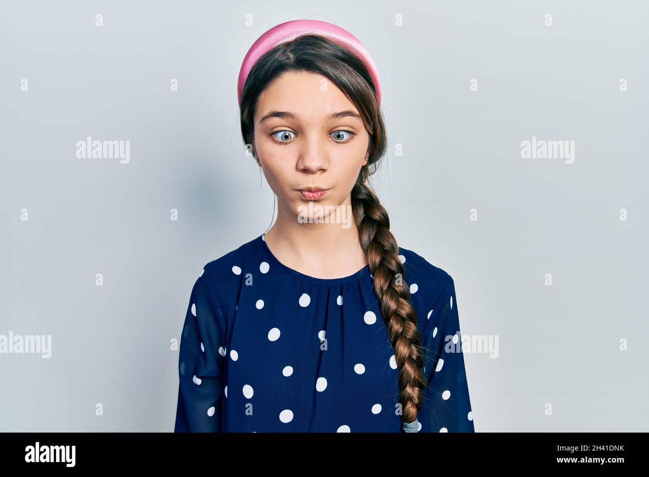 Young brunette girl wearing elegant look making fish face with lips ...