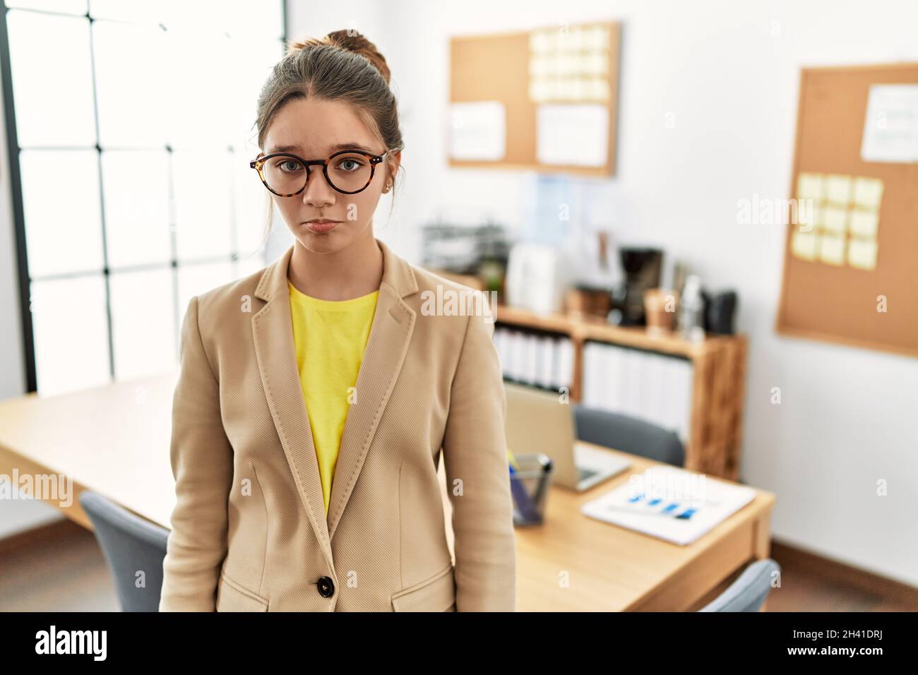 Young brunette teenager wearing business style at office depressed and ...