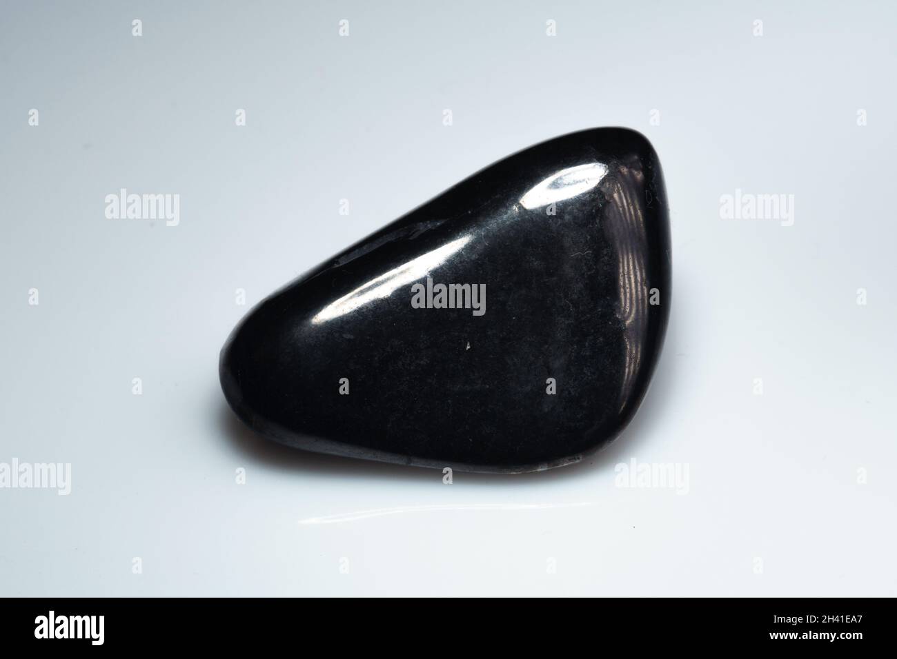 natural black shungite cabochon on background Stock Photo - Alamy