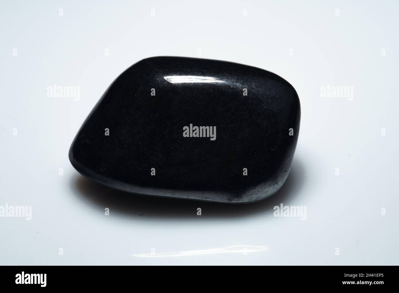 natural black shungite cabochon on background Stock Photo - Alamy