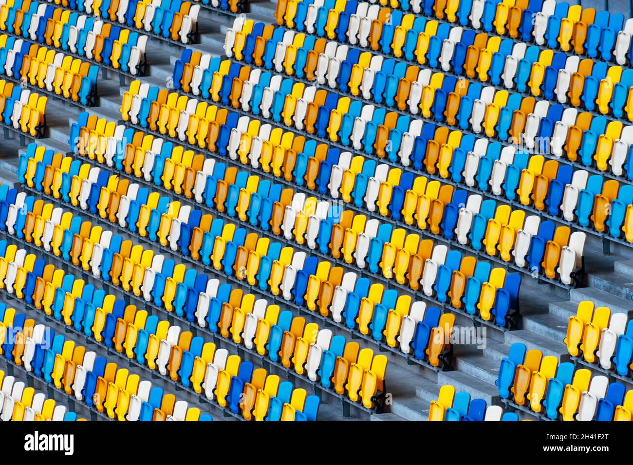 Blurred sitting fans colored plastic chairs at the football stadium ...