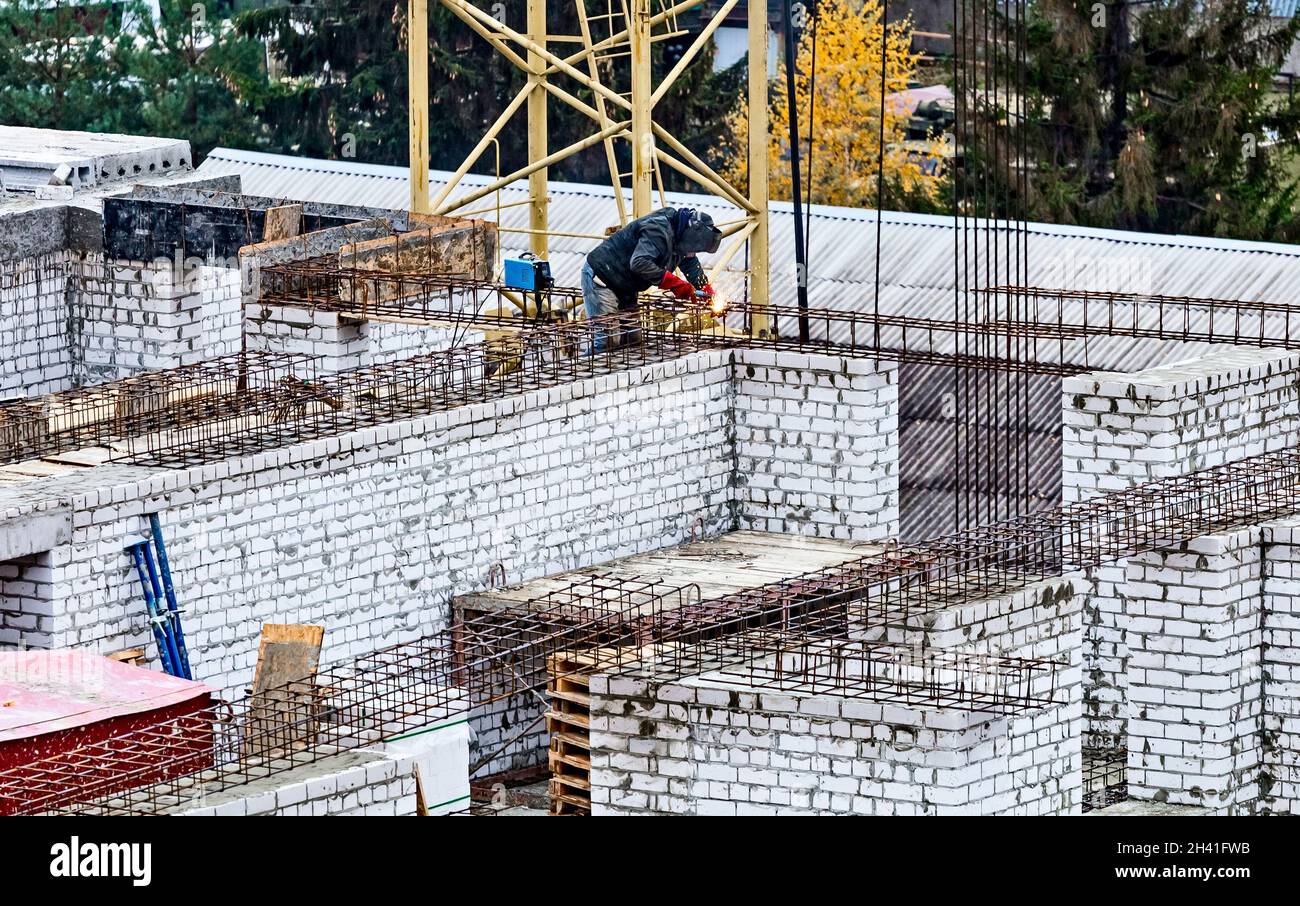 Welder worker welding building metal iron reinforcement elements at the ...