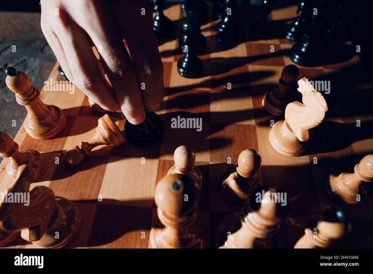 Young adult handsome man playing chess in dark with side lit Stock ...