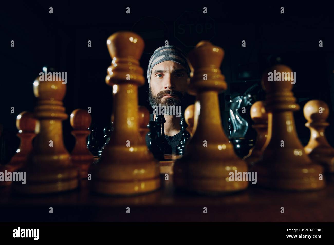 Young adult handsome man playing chess in dark with side lit Stock ...