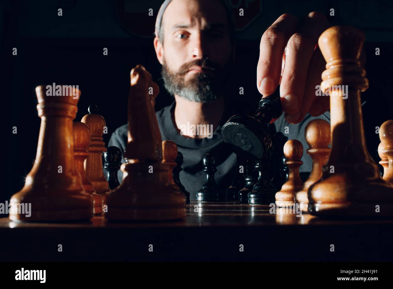 Young adult handsome man playing chess in dark with side lit Stock ...