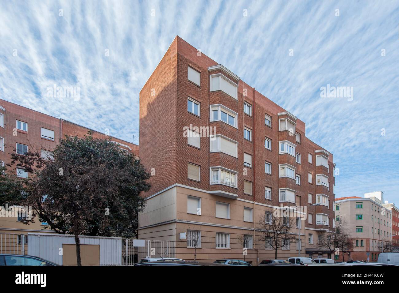 Red clay brick building facade with large windows on a winter day with ...