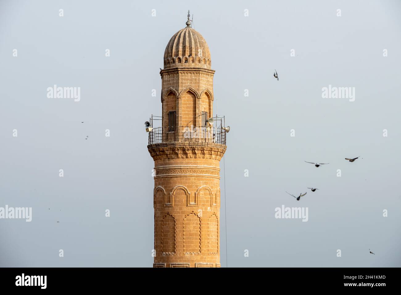 Top of a red sandstone minaret with speakers for the call to prayer and ...