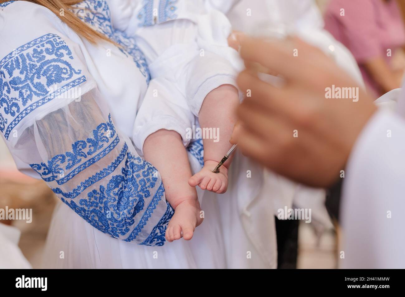 sacrament of baptism the priest baptizes the child with anointing Stock ...