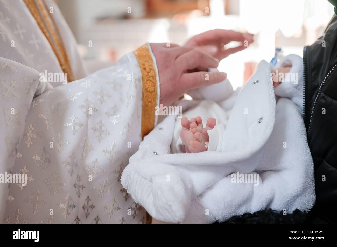 sacrament of baptism the priest baptizes the child with anointing Stock ...