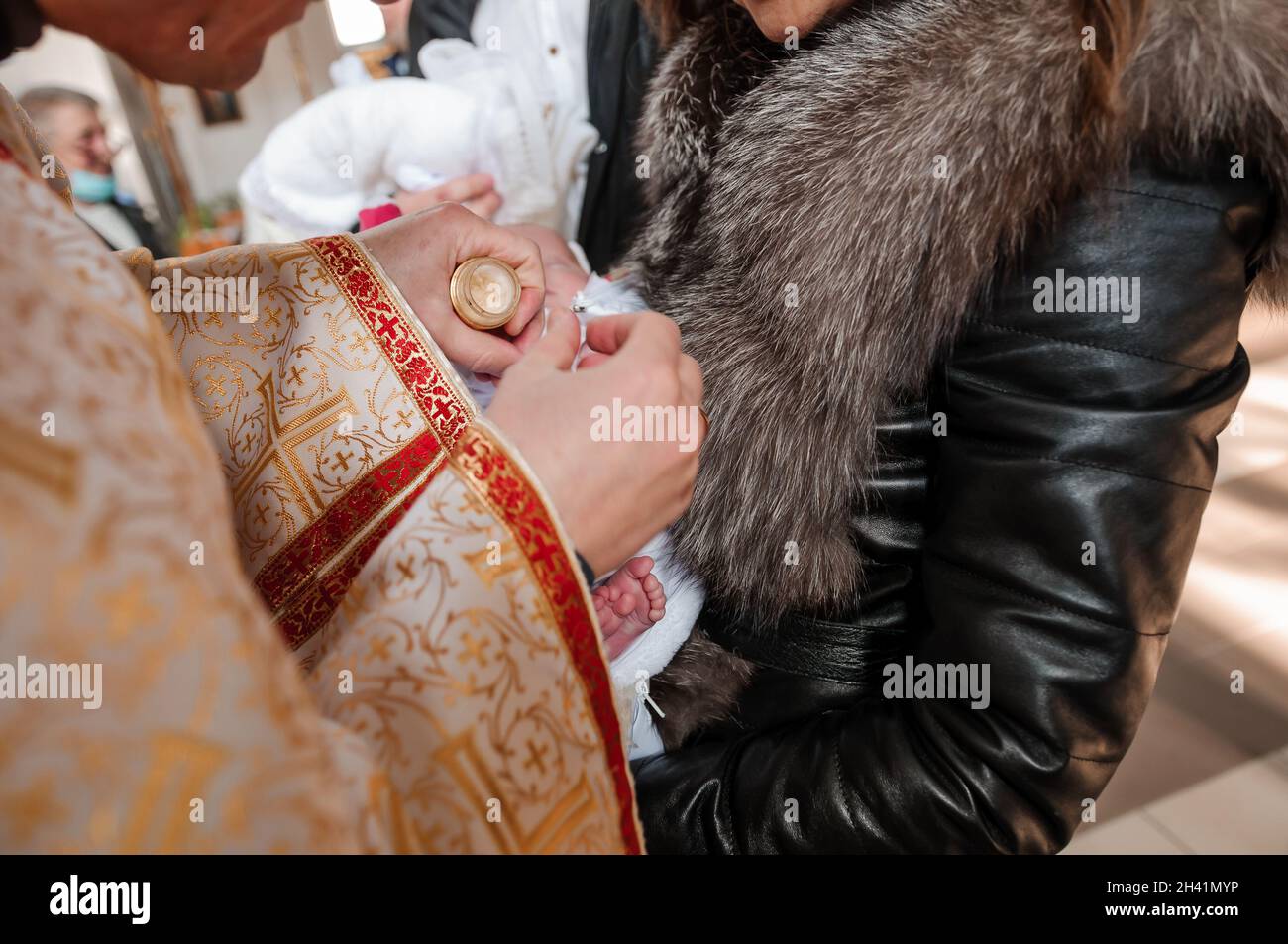 sacrament of baptism the priest baptizes the child with anointing Stock ...