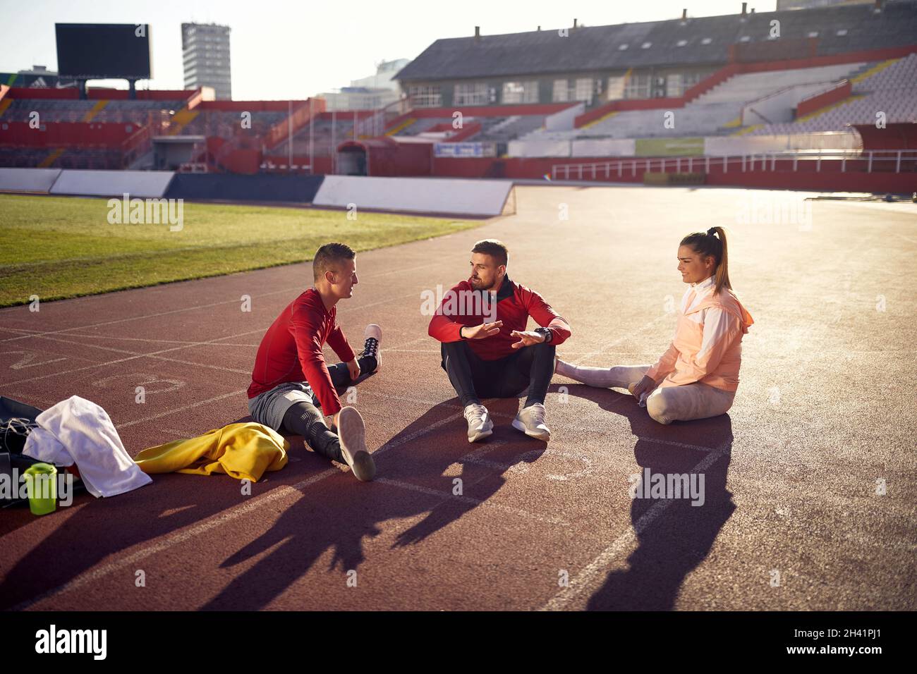 Group of professional athletes stretching together at the practice ...