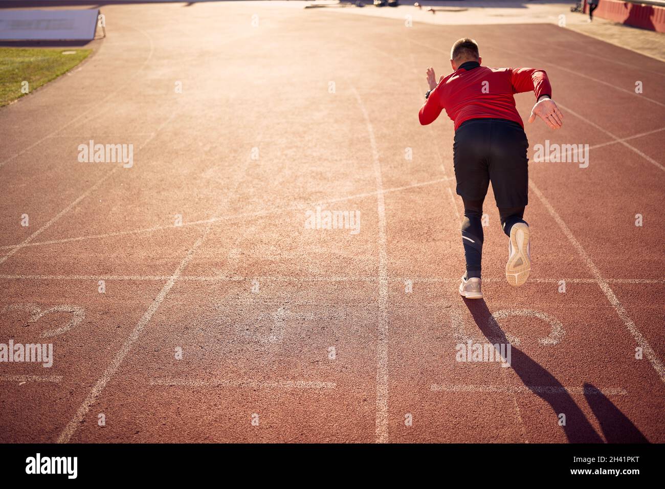 horizontal image of young adult male athlete from behind starting of ...