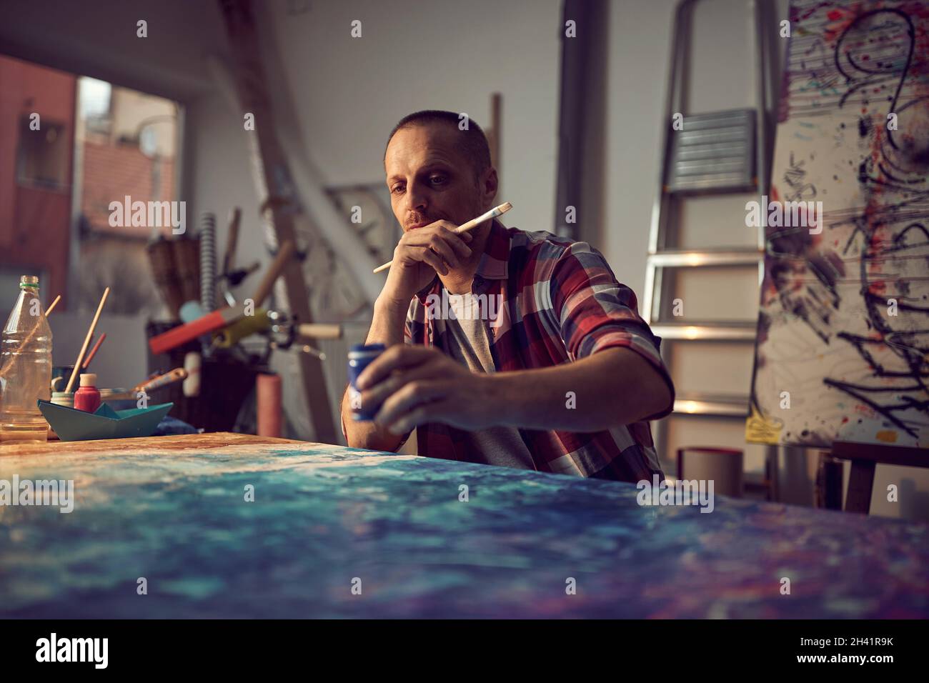 Man painter at workspace. Artist working on new paint Stock Photo - Alamy