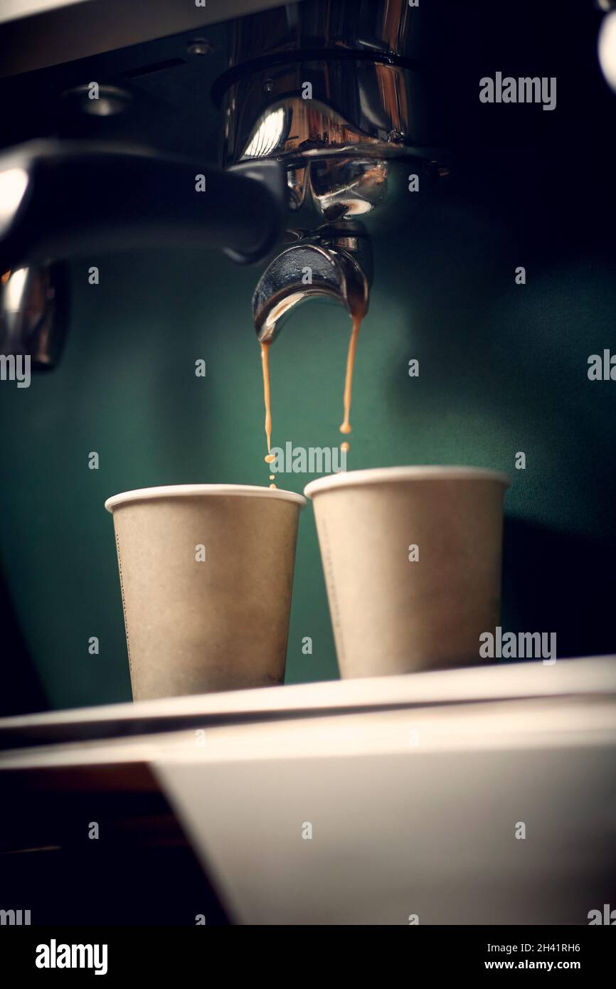 Cups are filling with a fragrant and aromatic coffee in the espresso ...