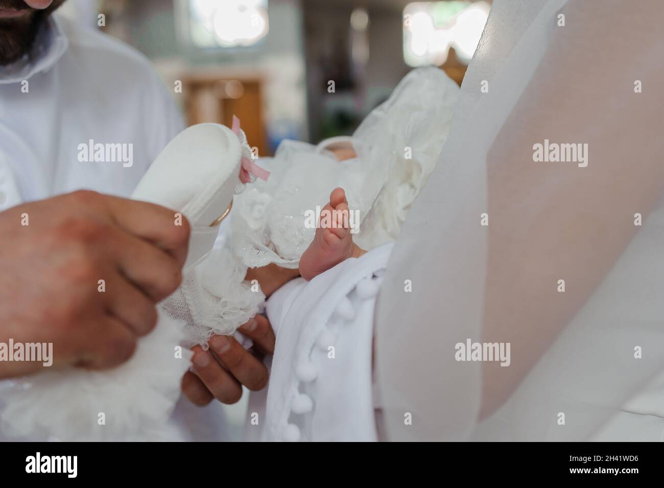sacrament of baptism the priest baptizes the child with anointing Stock ...