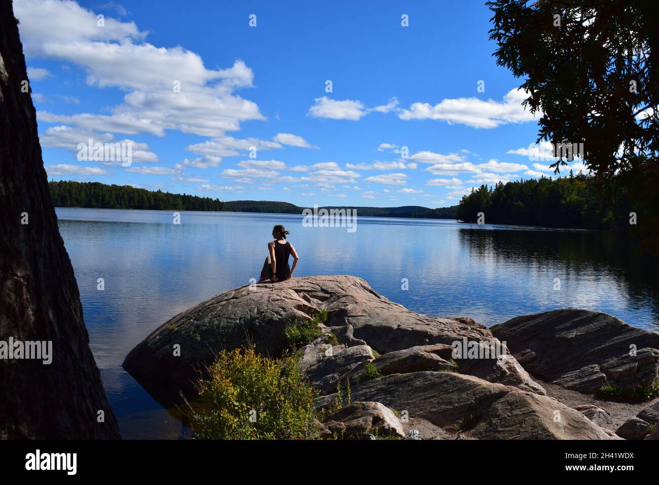 Woman looking out over a lake in Canada Stock Photo - Alamy