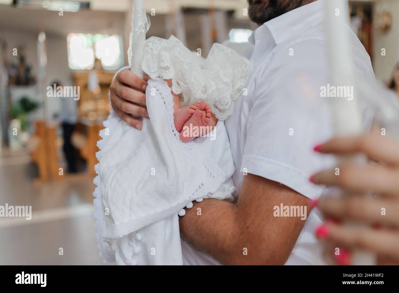 sacrament of baptism the priest baptizes the child with anointing Stock ...