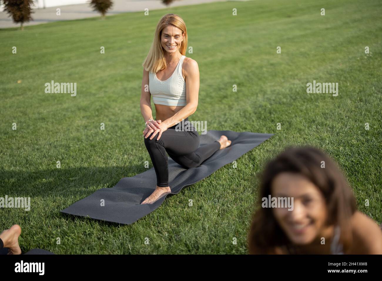 Girls stretching before sports training on lawn Stock Photo - Alamy