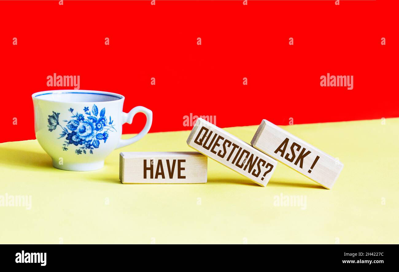 Have questions Ask, text is written on wooden blocks and a red and ...