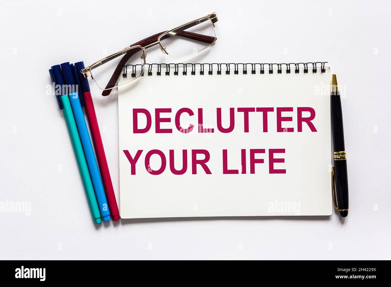 Declutter your life, text is written on a white notepad with stationery ...