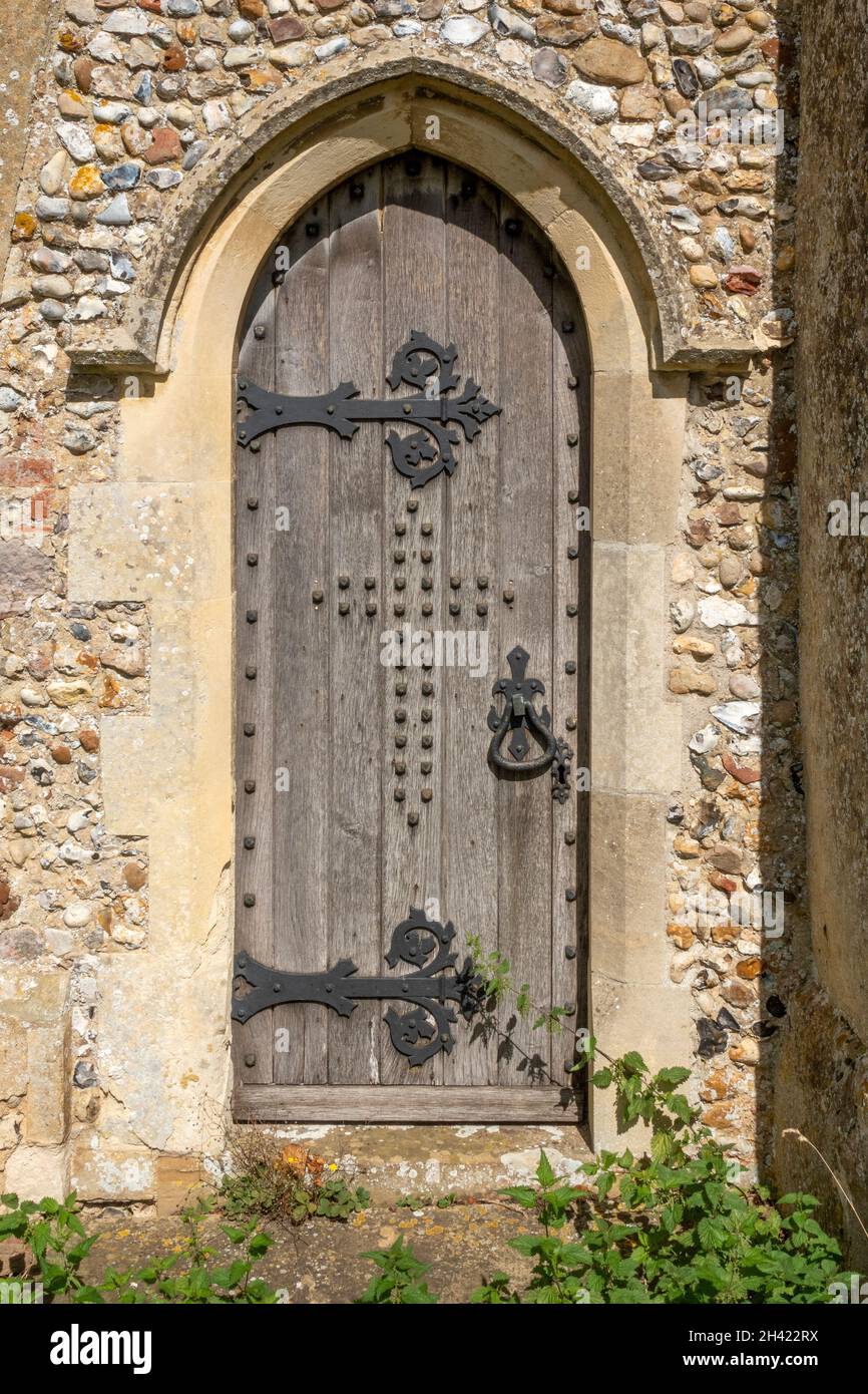 Wooden door set in stone arch frame with ornate metal hinges at St ...
