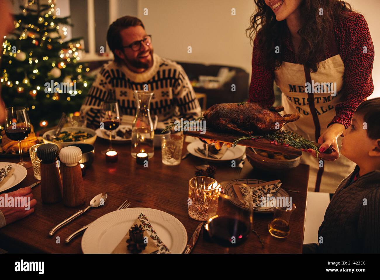Woman serving roasted turkey for family dinner at home. Woman serving ...