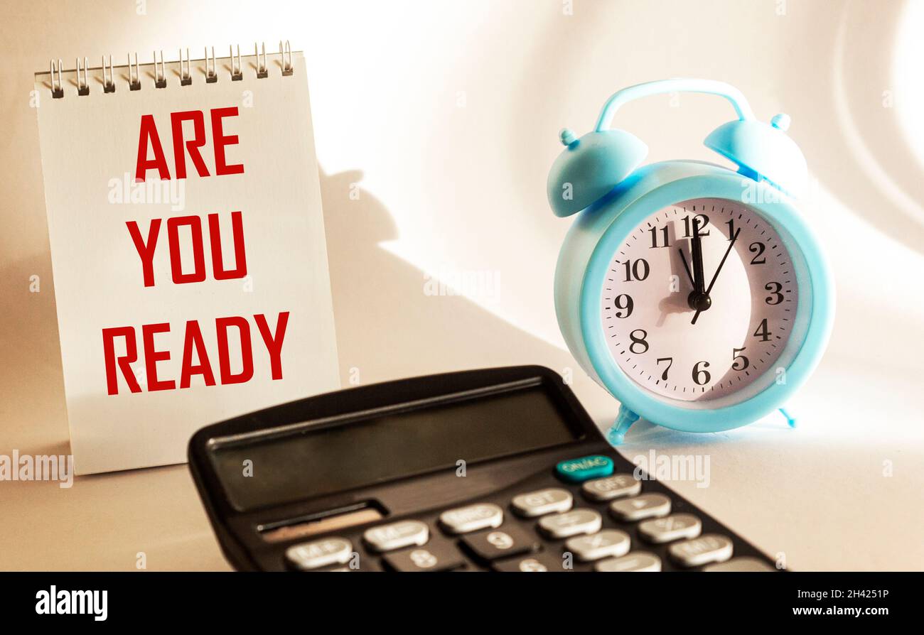 Are you ready Text written on a page of a notebook, alarm clock and ...