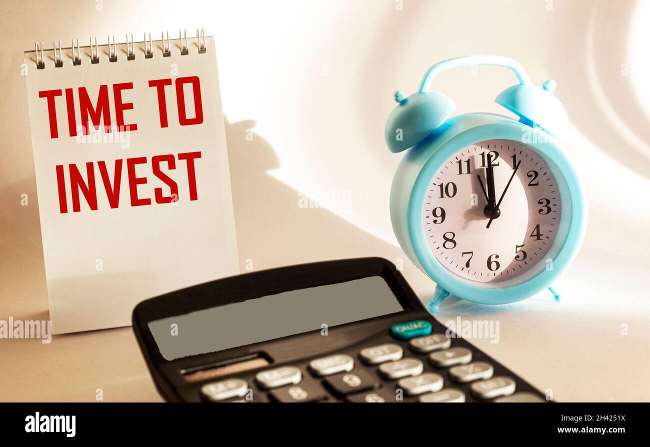 Notepad on white background with text Time to Invest Stock Photo - Alamy