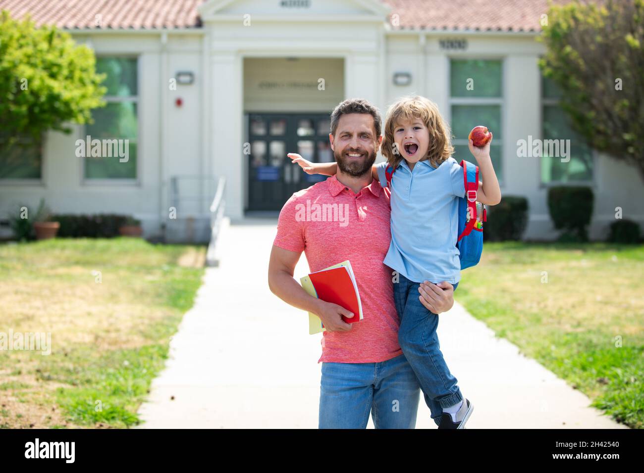 Father leads a little child school boy in first grade. Father supports ...