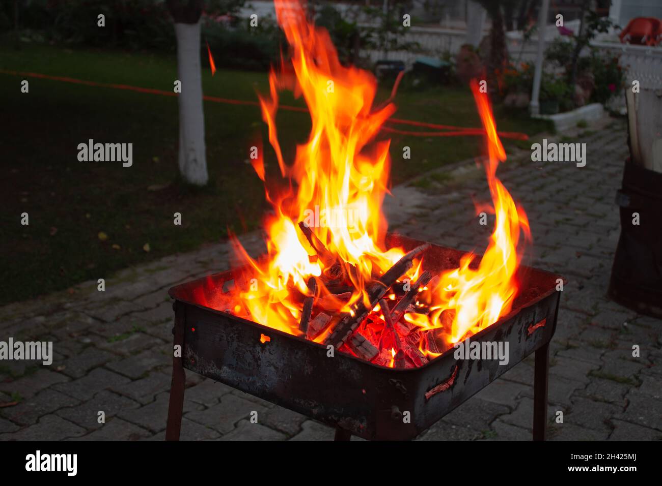 Stacked wooden pieces in a grill burning in orange fire. Preparation ...