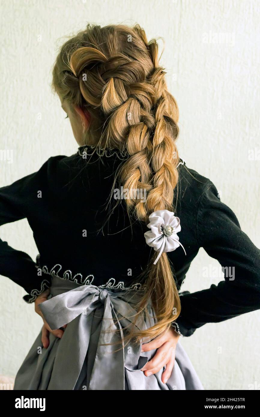 On the head of a little girl, in festive clothes, beautifully woven ...