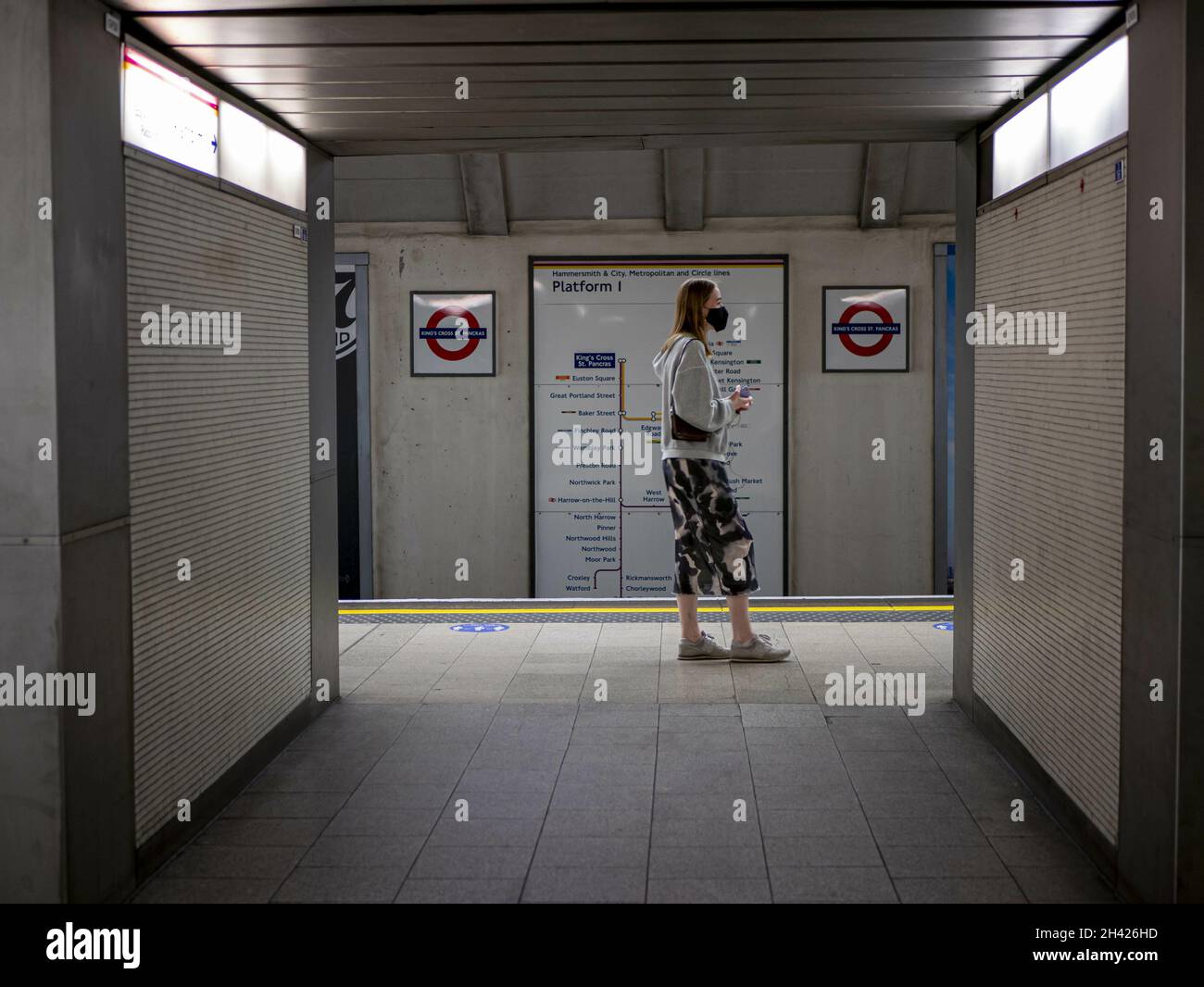 A young female with a protective mask standing at the underground Stock ...