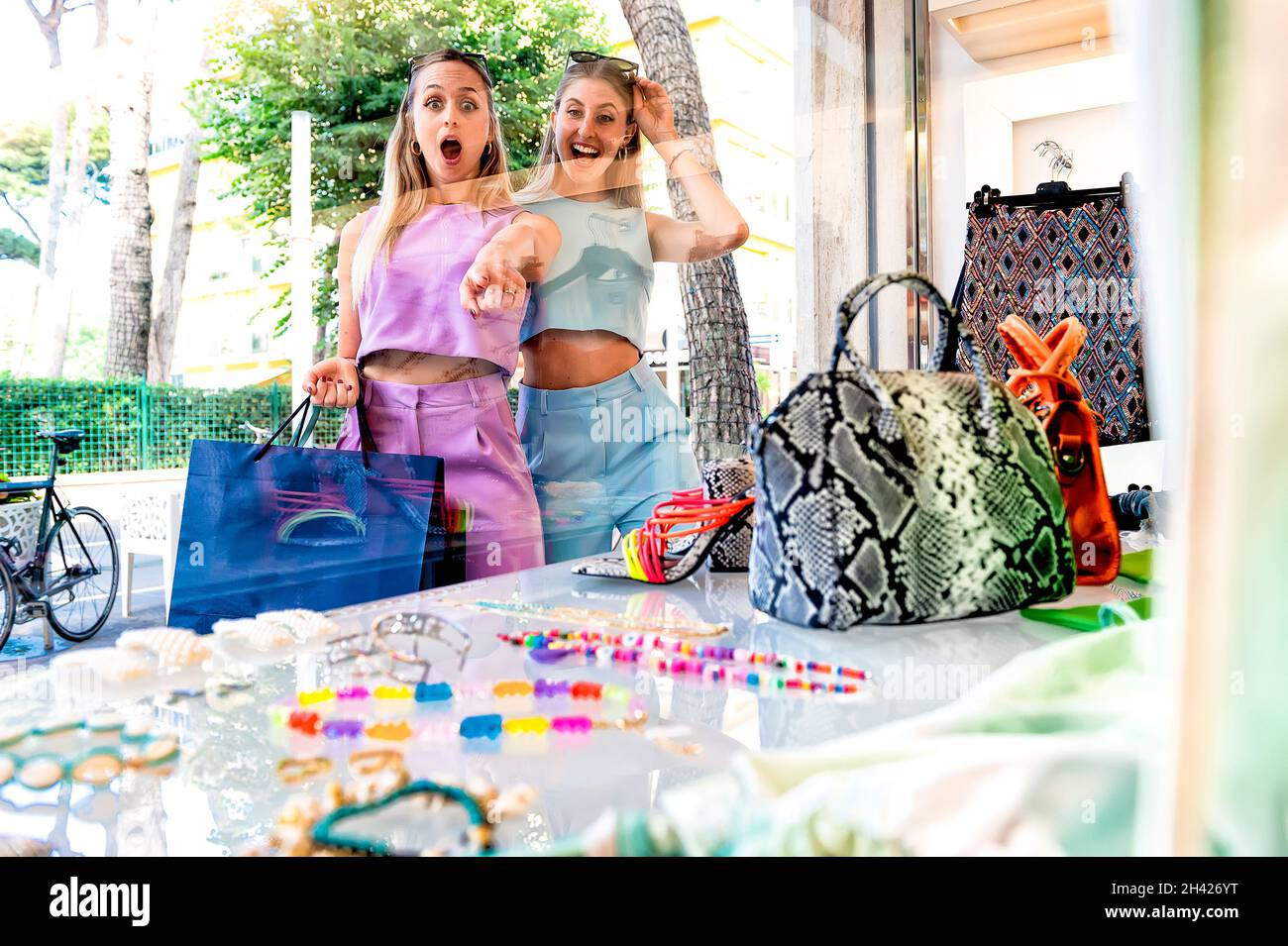 Amazed shopper girl opening mouth holding shopping bags watching ...