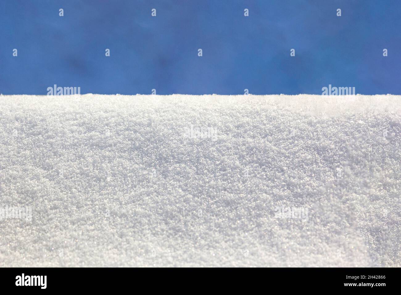 In clear sunny weather, clean snow background against the blue sky ...
