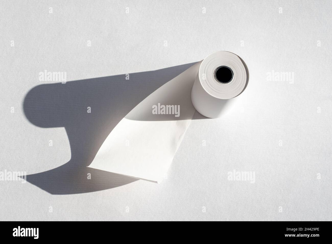 Roll Of Cassette Paper Tape With Shadow On White Paper Copy Space Roll Of Cash Register Tape