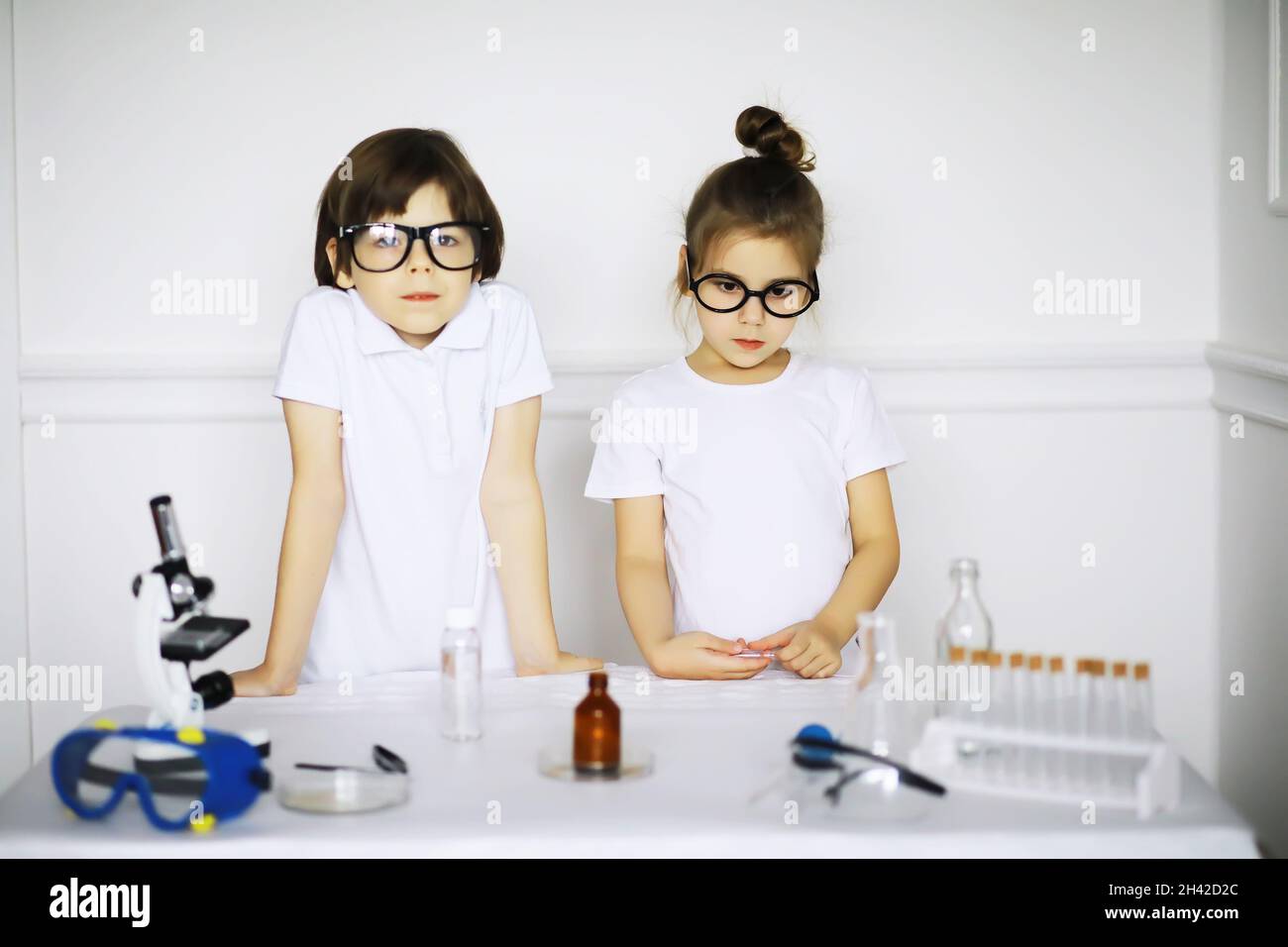 Two cute children at chemistry lesson making experiments isolated on ...