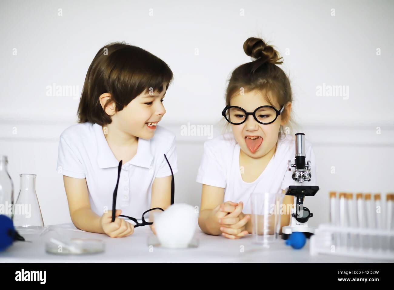 Two cute children at chemistry lesson making experiments isolated on ...