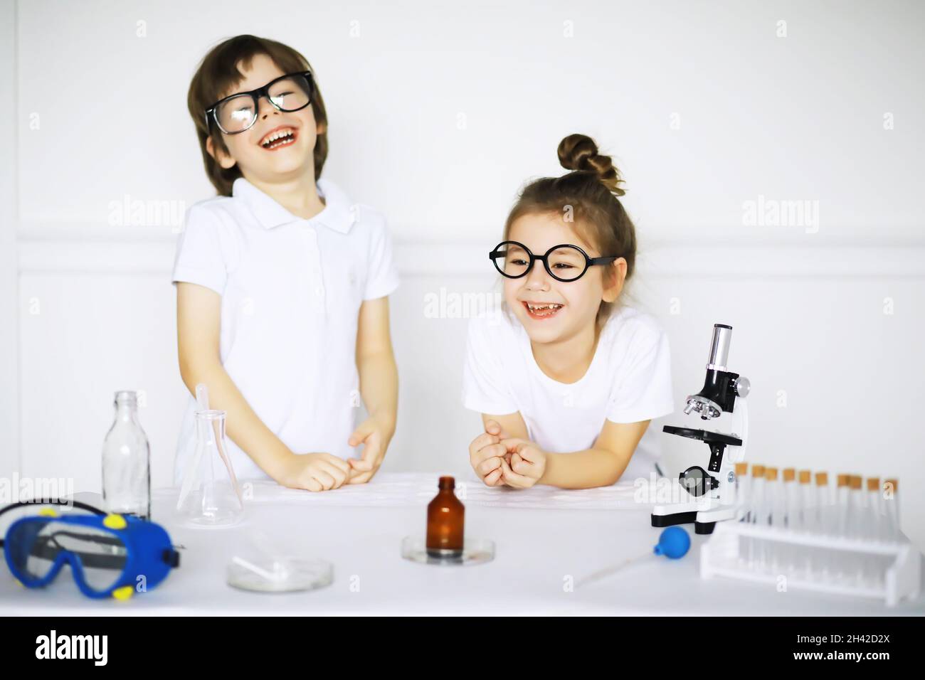 Two cute children at chemistry lesson making experiments isolated on ...